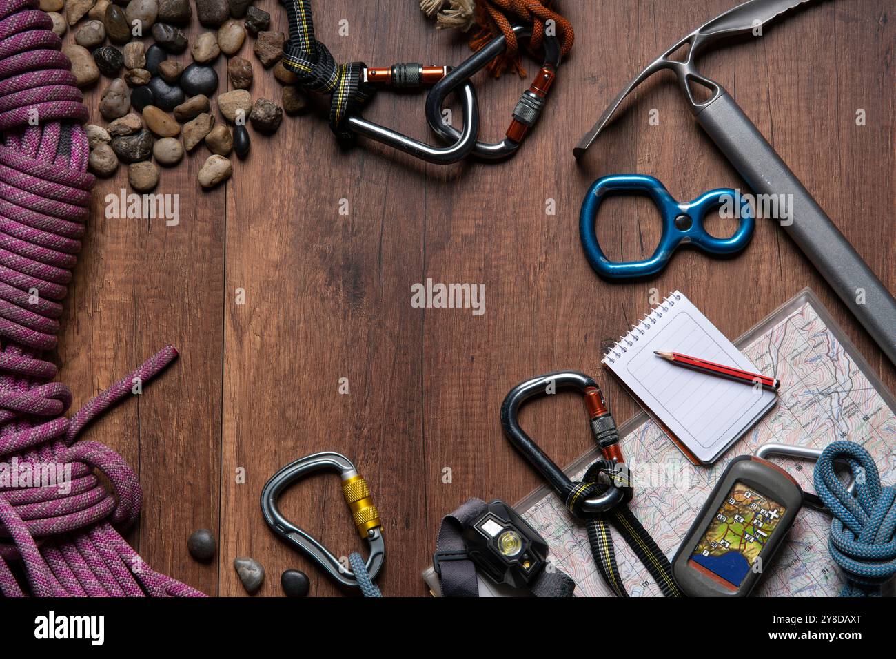 Top view of wooden table with climbing equipment, rope, carabiners, ice ...