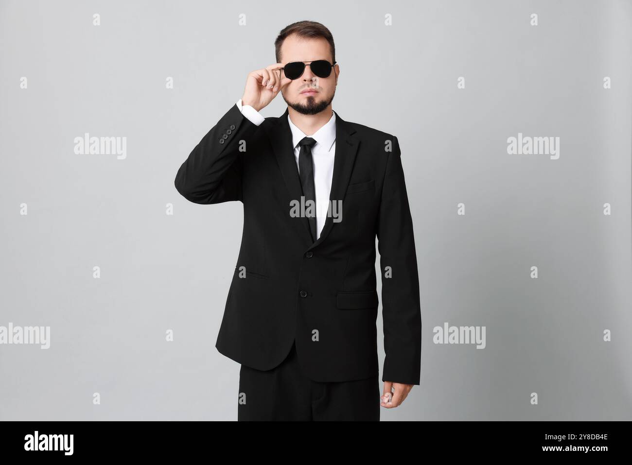 Young bodyguard in suit and sunglasses on grey background Stock Photo ...