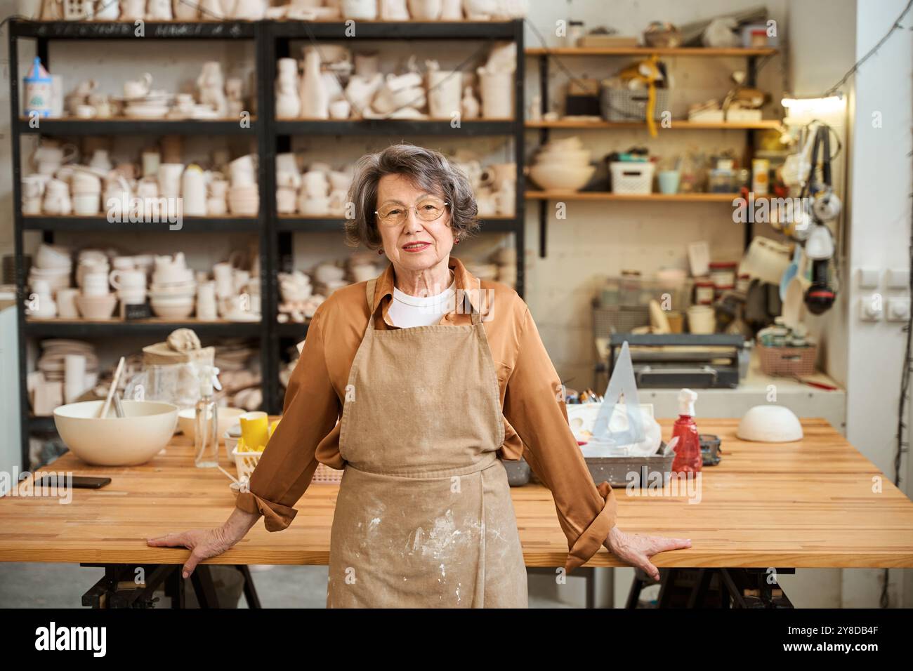 Female in a pottery apron stands in the pottery room Stock Photo - Alamy
