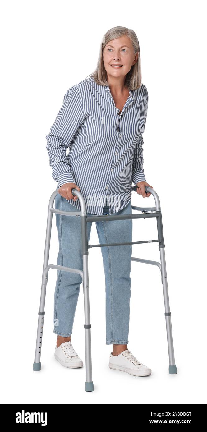 Senior woman using walking frame on white background Stock Photo - Alamy