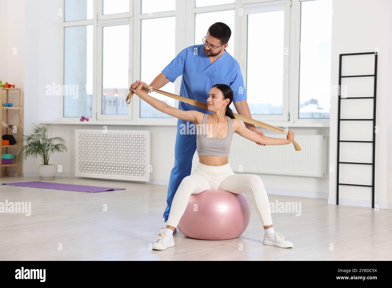 Patient exercising under physiotherapist supervision in rehabilitation ...