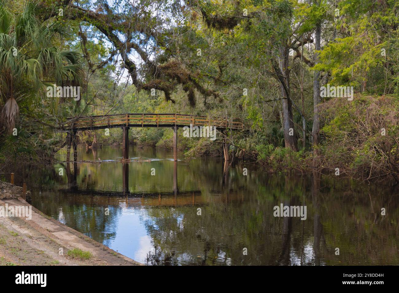 The river reflects the blue sky and footbridge at the Hillsboro River ...