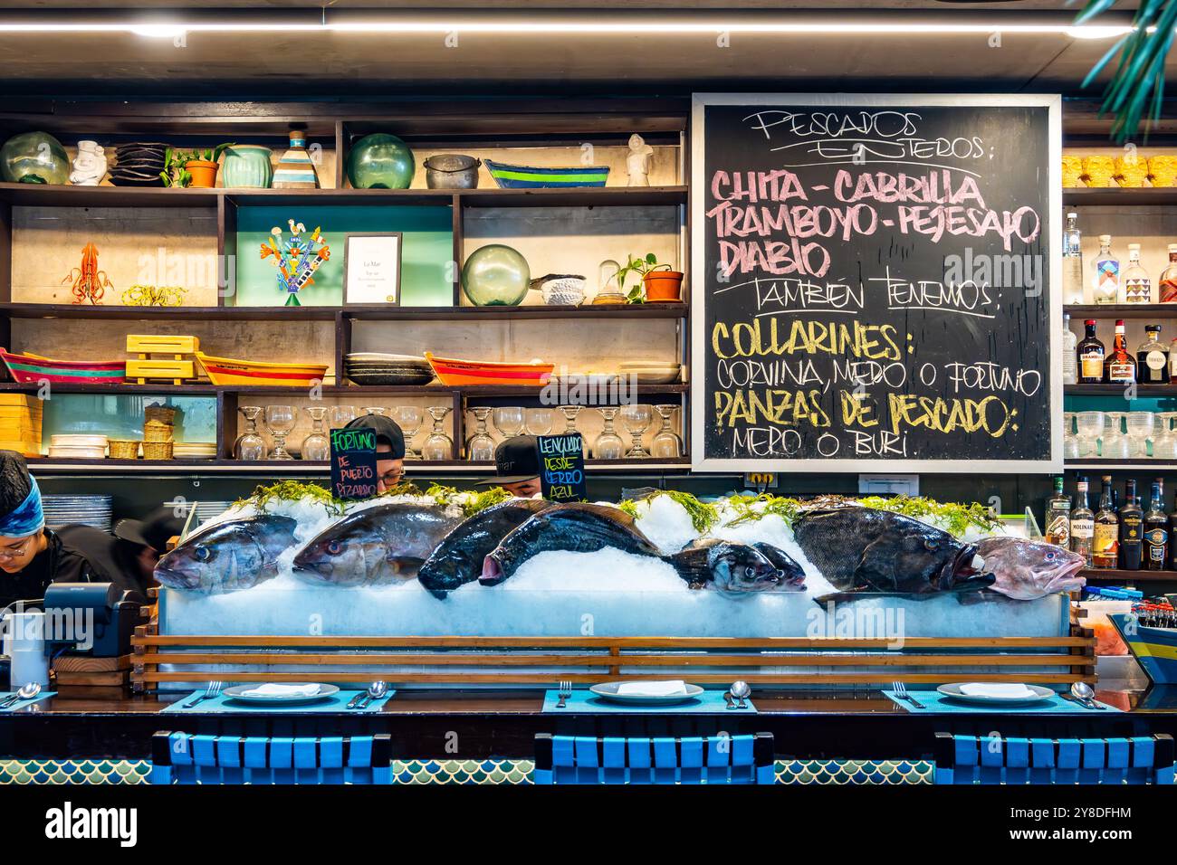 Hand written menu on blackboard, fresh fish and seafood on ice in ...