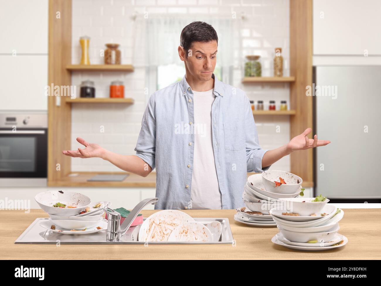 Angry man with a pile of dirty dishes in a kitchen sink Stock Photo - Alamy