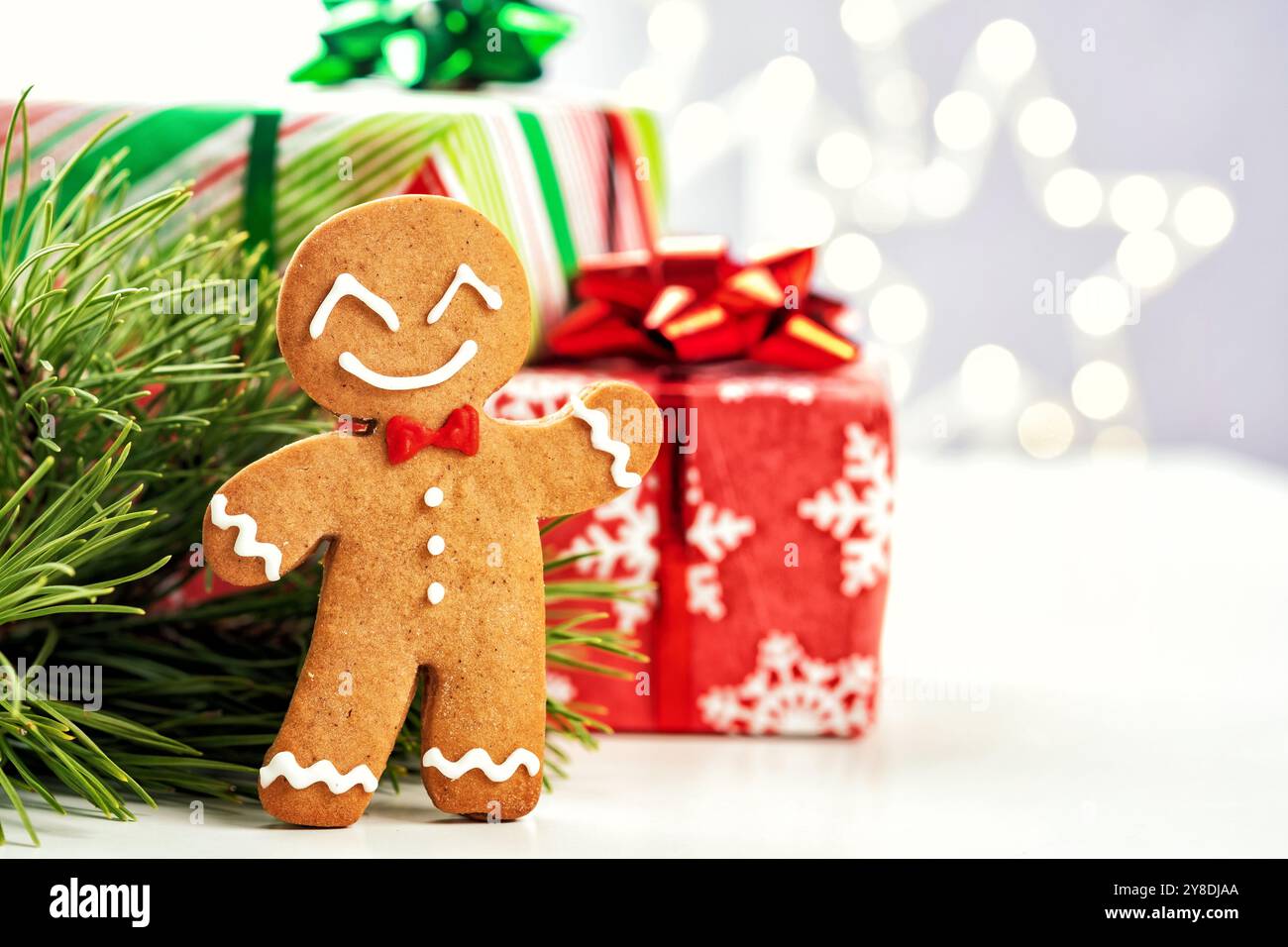Two gingerbread men are smiling and standing next to a stack of ...