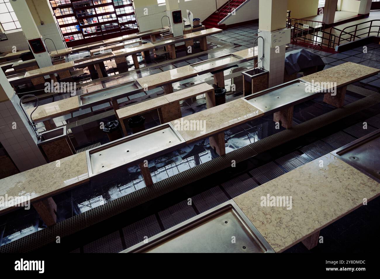 Empty market stalls with tiled counters and drainage, inside Funchal’s ...