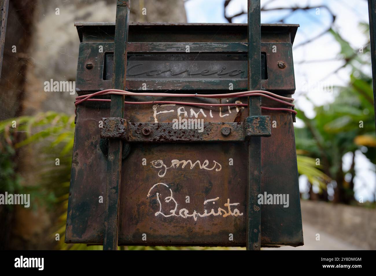 Weathered family mailbox with handwritten names, wrapped in wire ...