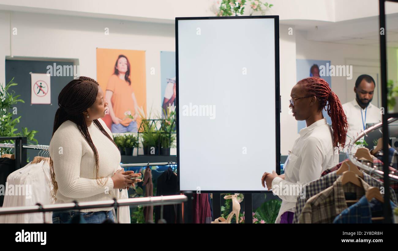 African american shopkeeper in clothing store using augmented reality ...