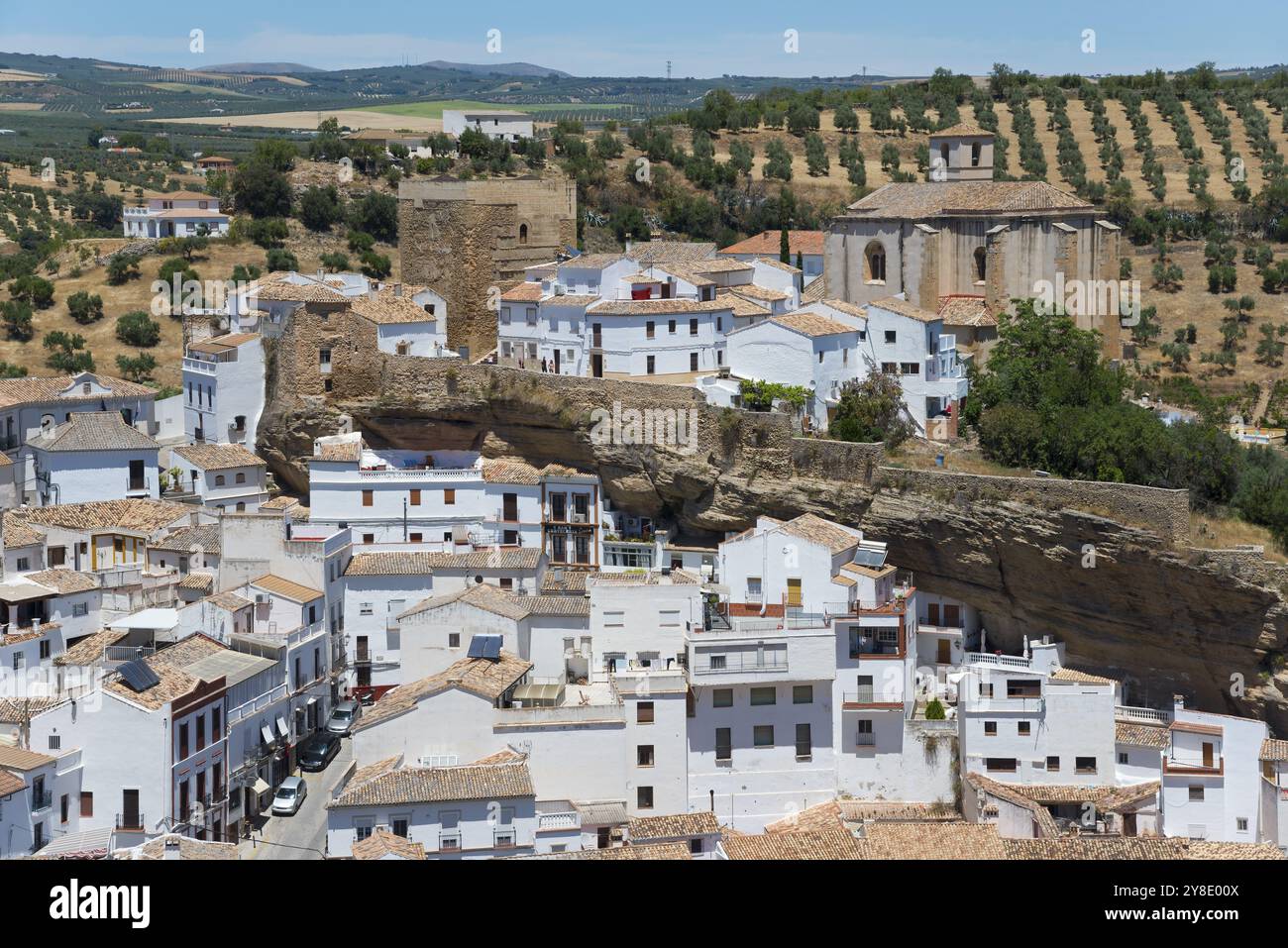 Historic buildings in a white village nestled in an impressive rock ...