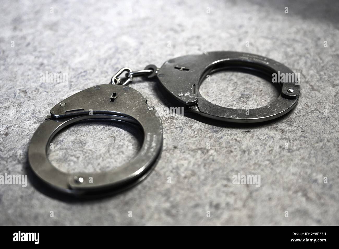 Silver handcuffs on a grey background symbolise criminality Stock Photo ...