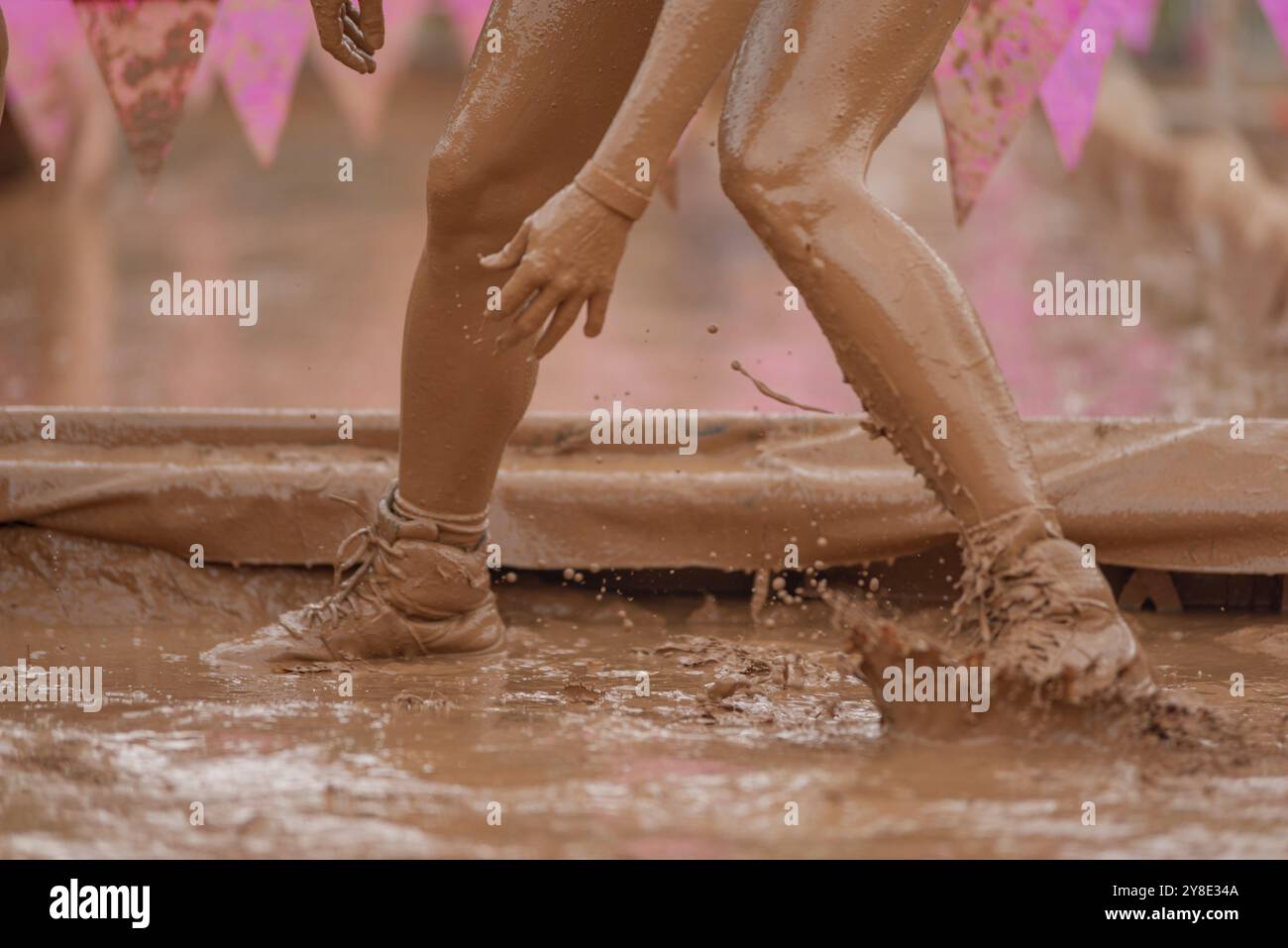 Person traverses muddy terrain in an athletic obstacle course Stock ...