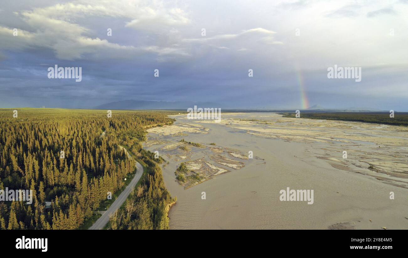 A big wide muddy river flows off Glaciers of the Denali Range towards ...