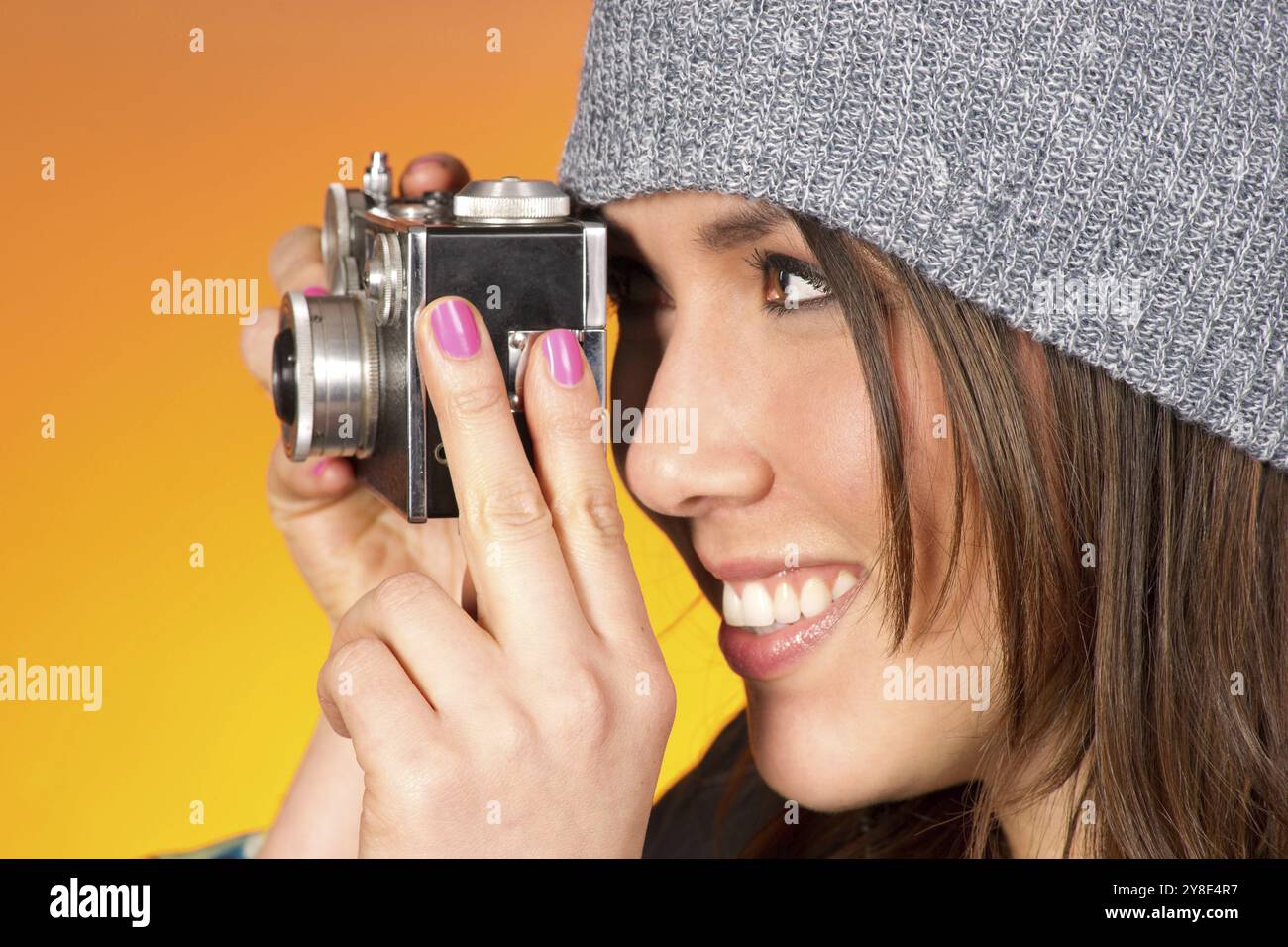 Hip Attractive Woman in Beanie Cap Snaps a Picture with Vintage Camera ...