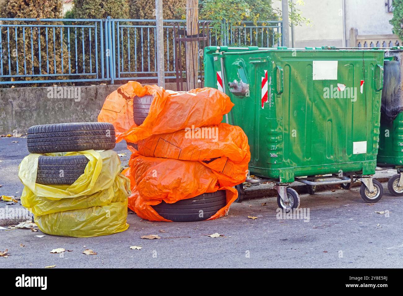 Wrong disposal of rejected tires at street near trash bin Stock Photo ...
