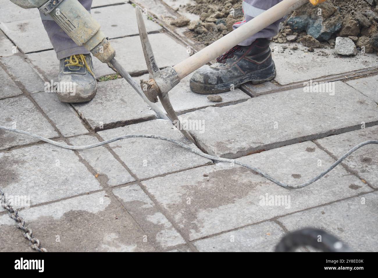 A construction worker is currently using an electric jackhammer to ...