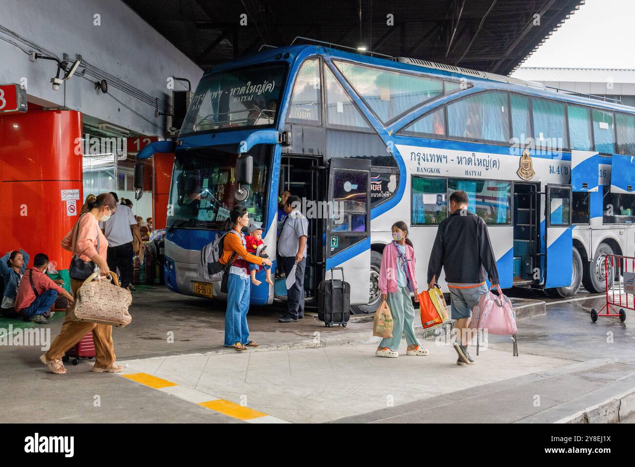 A family with kids is seen walking to a double-decker bus, at Mo Chit ...