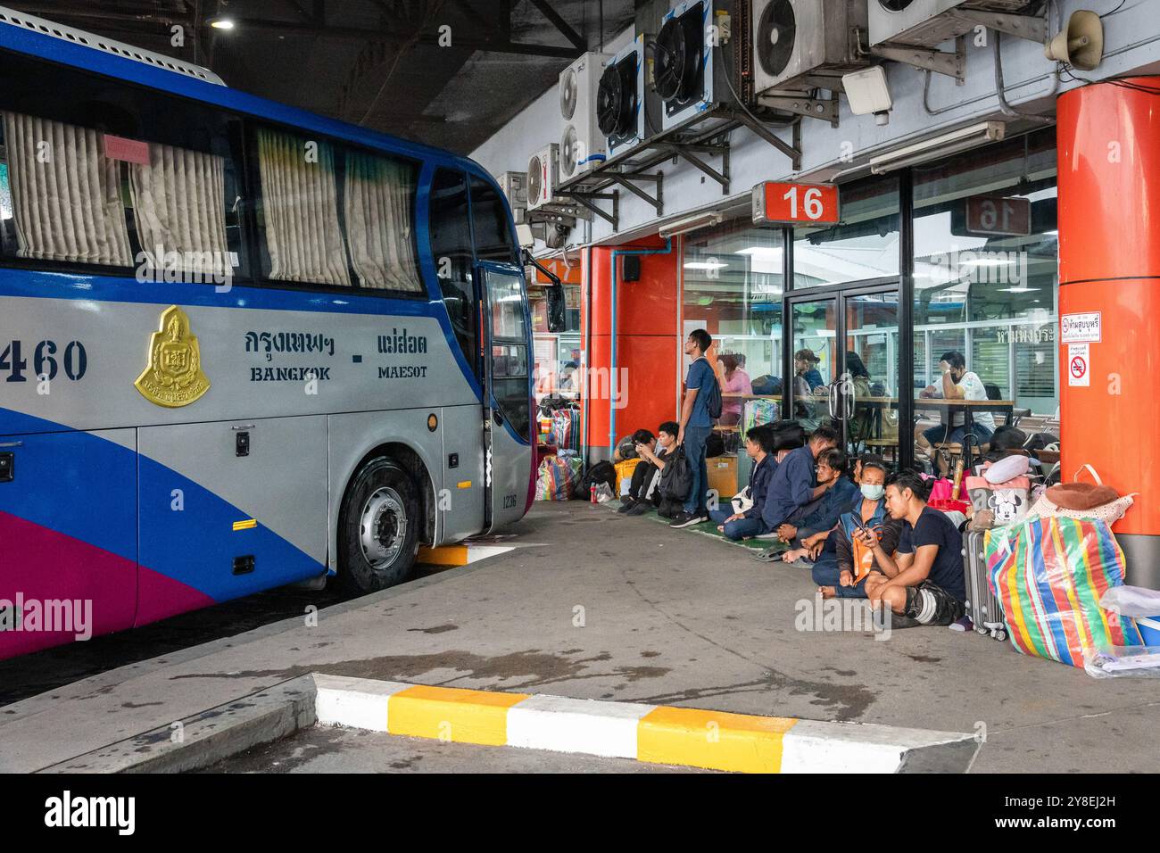 Passengers are seen sitting on the ground with their luggage in front ...