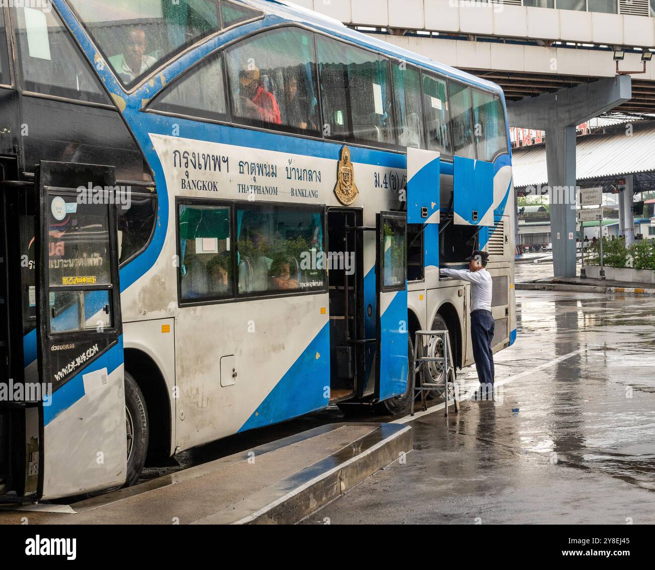 A double-decker bus driver is seen checking the storage compartment ...