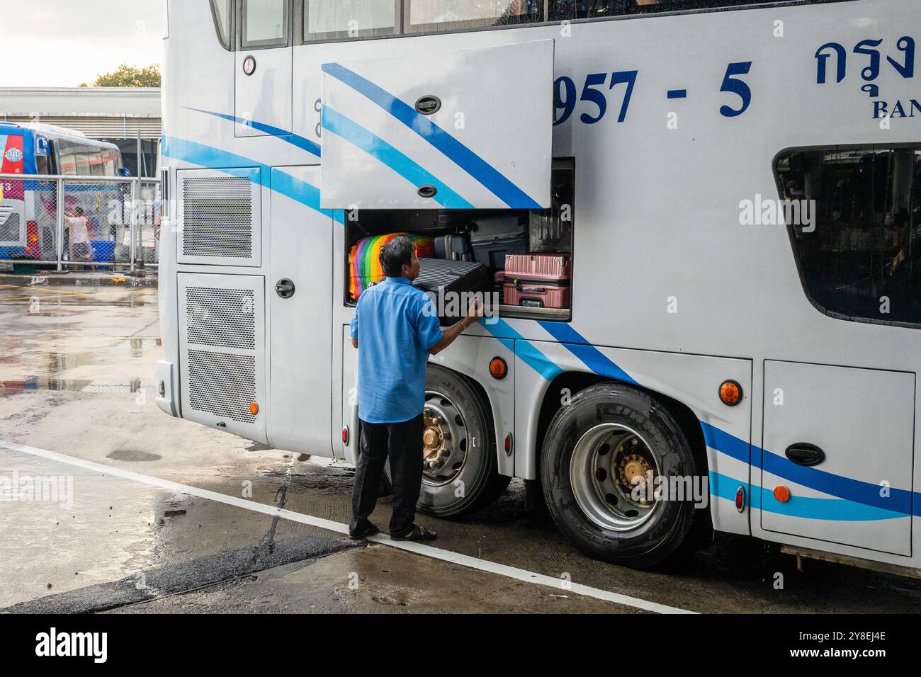 A double-decker driver is seen outside puting the passenger's luggage ...