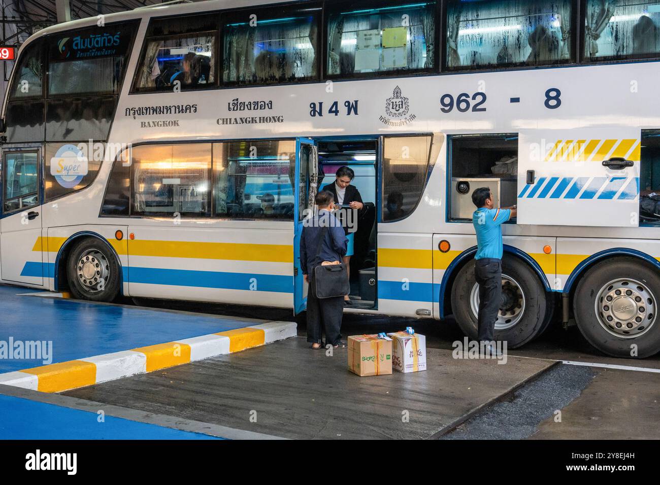 A bus hostess is seen checking the ticket of a passenger while the ...
