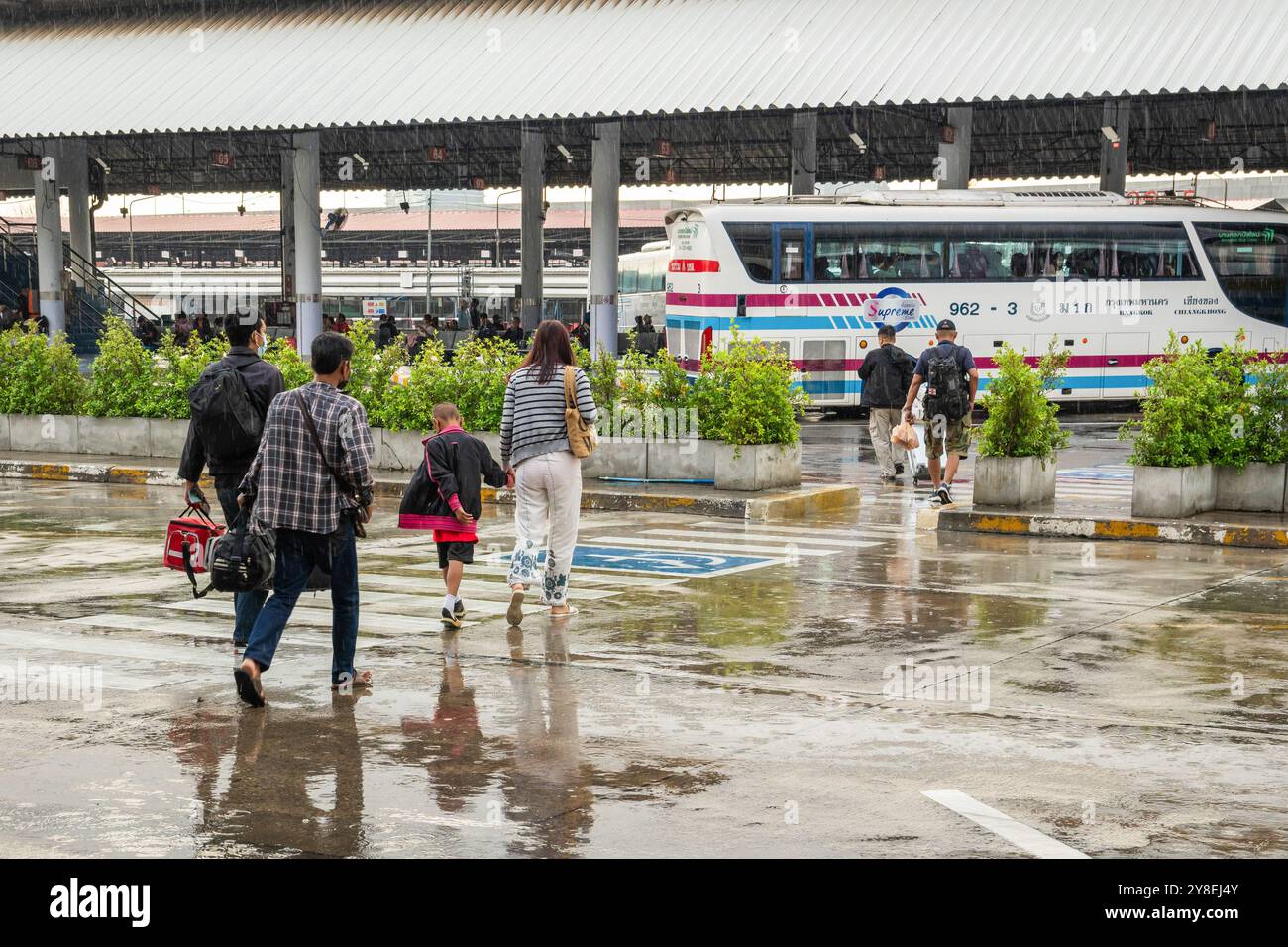 A view of a mother and her kid surrounded by other passengers crossing ...