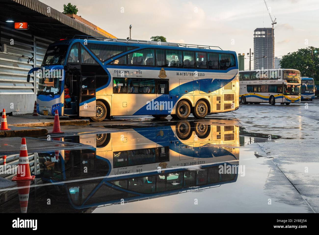 A view at sunset of a double-decker bus waiting for passengers, with ...