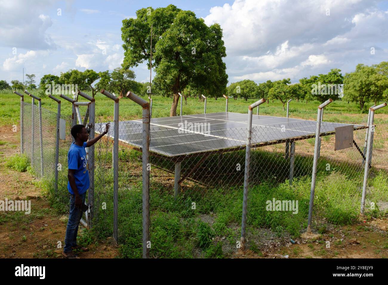 A young man stands by a community radio station solar setup sponsored ...