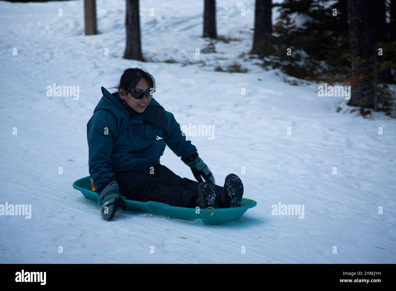 Woman rides a plastic toboggan down a snowy hill, Helena-Lewis & Clark ...