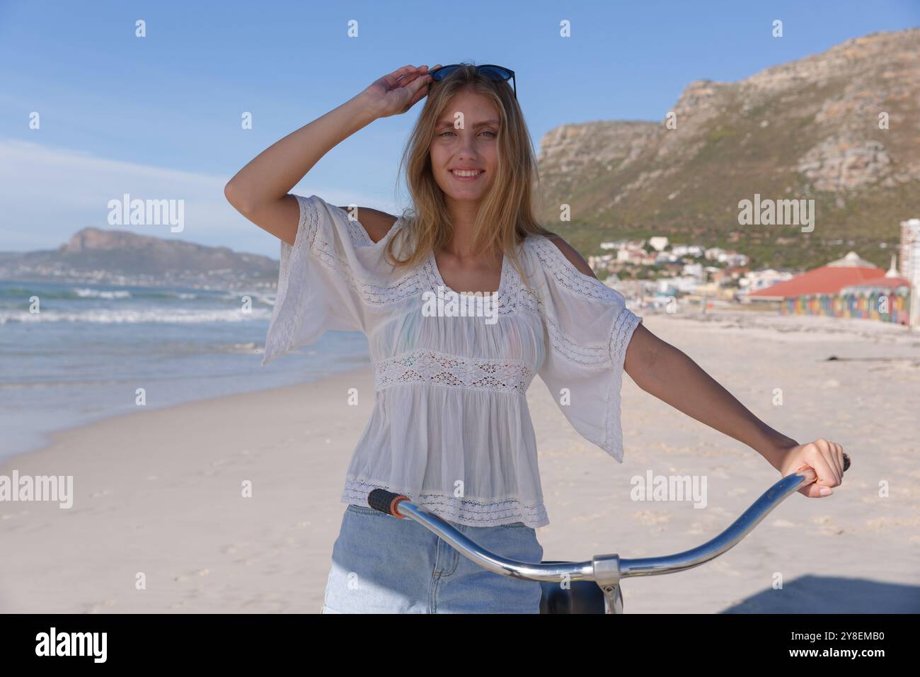 Caucasian woman riding a bicycle looking at the camera and smiling at ...