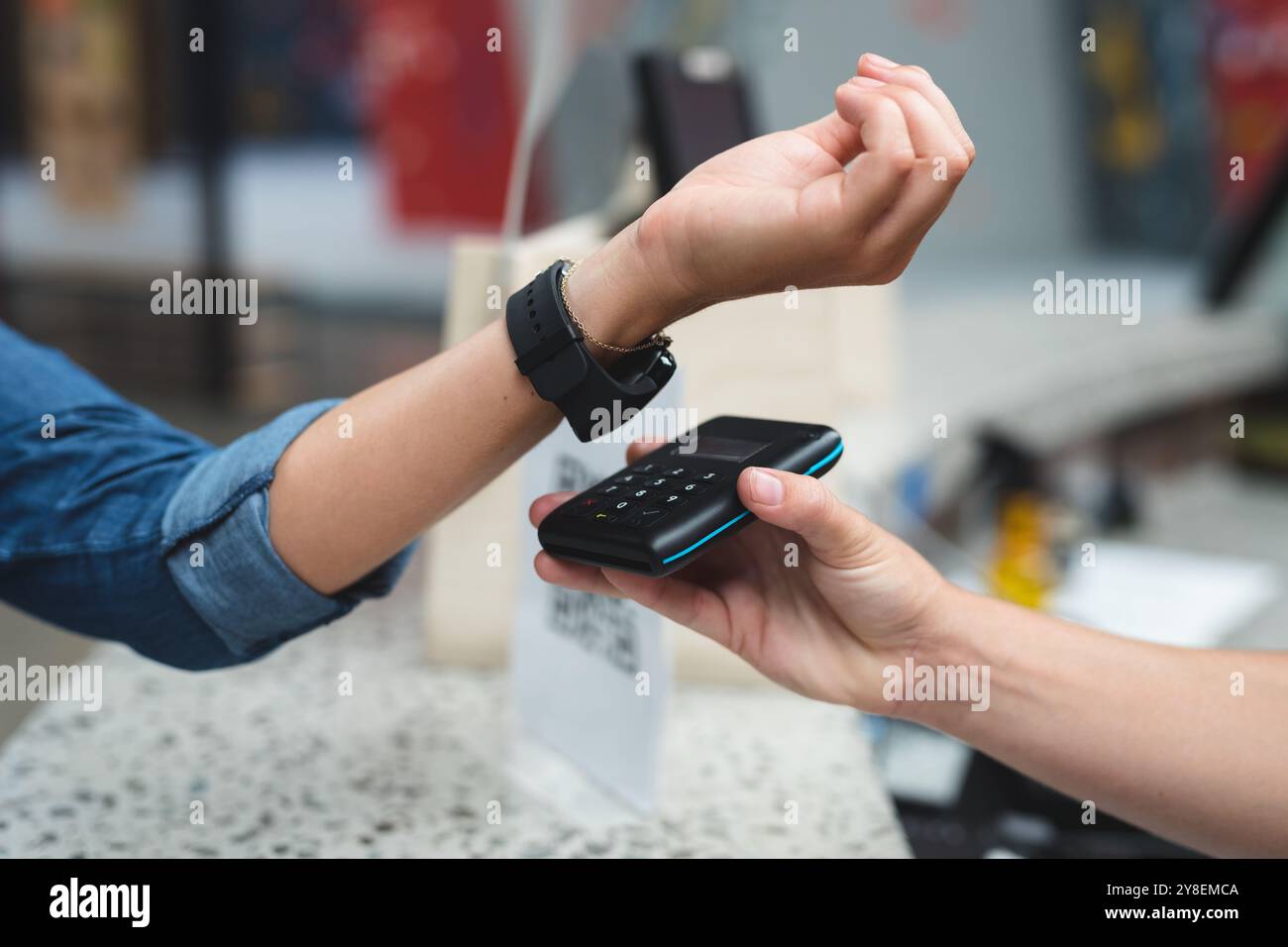 Midsection of caucasian woman making contactless watch payment over ...