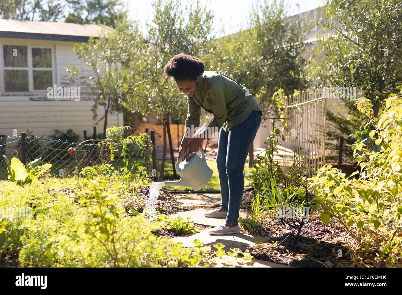 African woman watering plant hi-res stock photography and images - Alamy