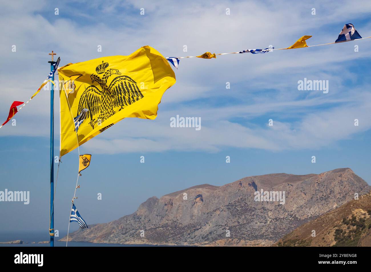 Flag of Greek Orthodox Church fluttering over landscape of a Greek ...