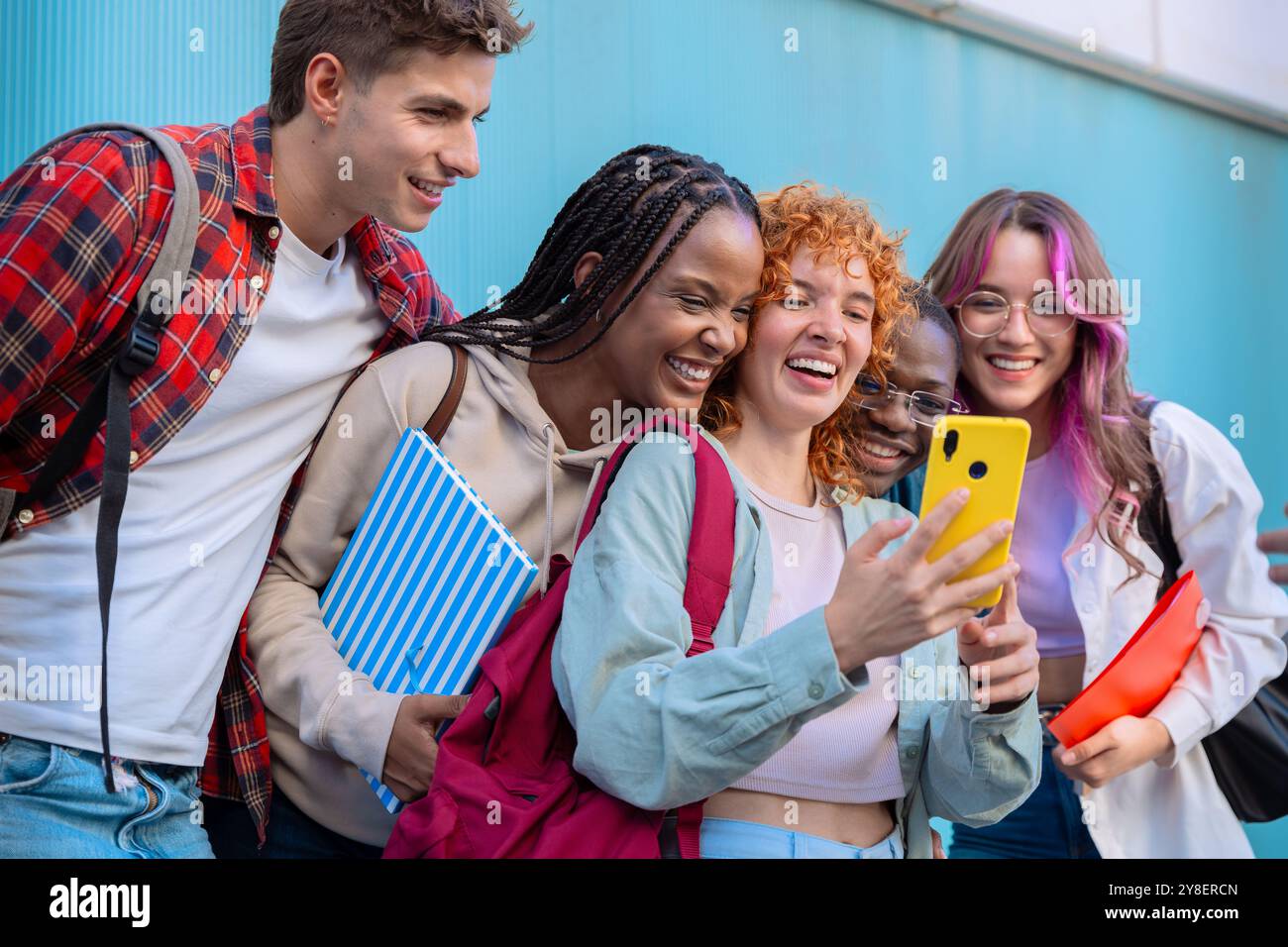 Five students having fun with mobile phones creating content on social ...