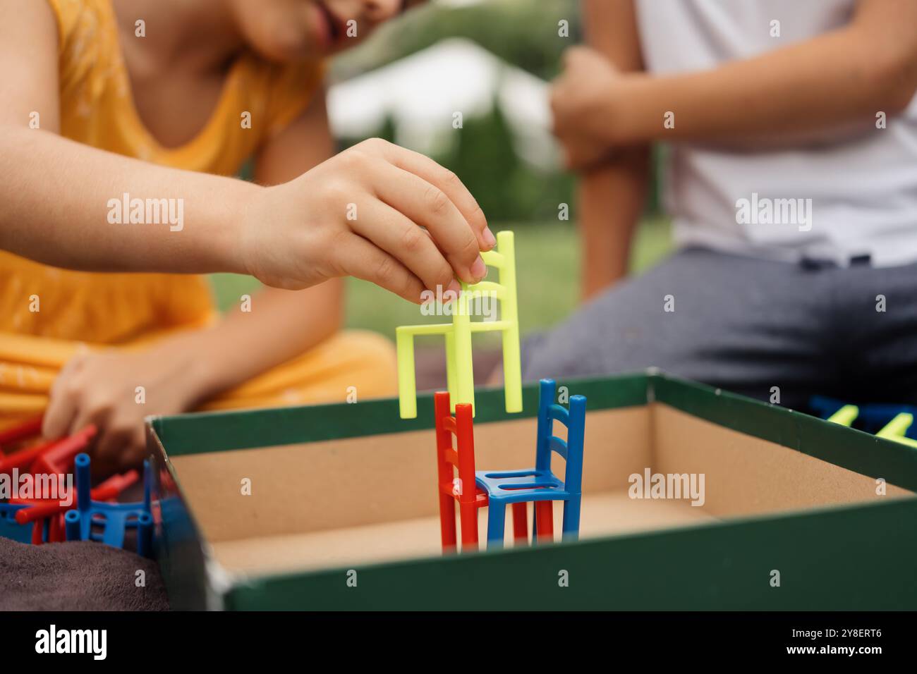 Children playing a fun stacking board game outdoors Stock Photo - Alamy
