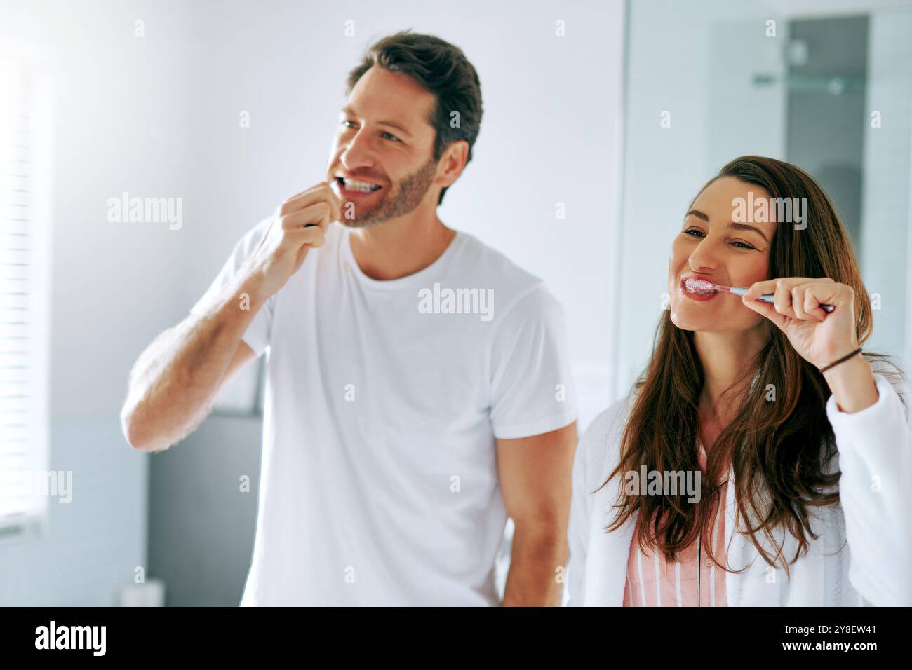 Brushing teeth, morning and cleaning with couple in bathroom for oral hygiene, breath and dental ...