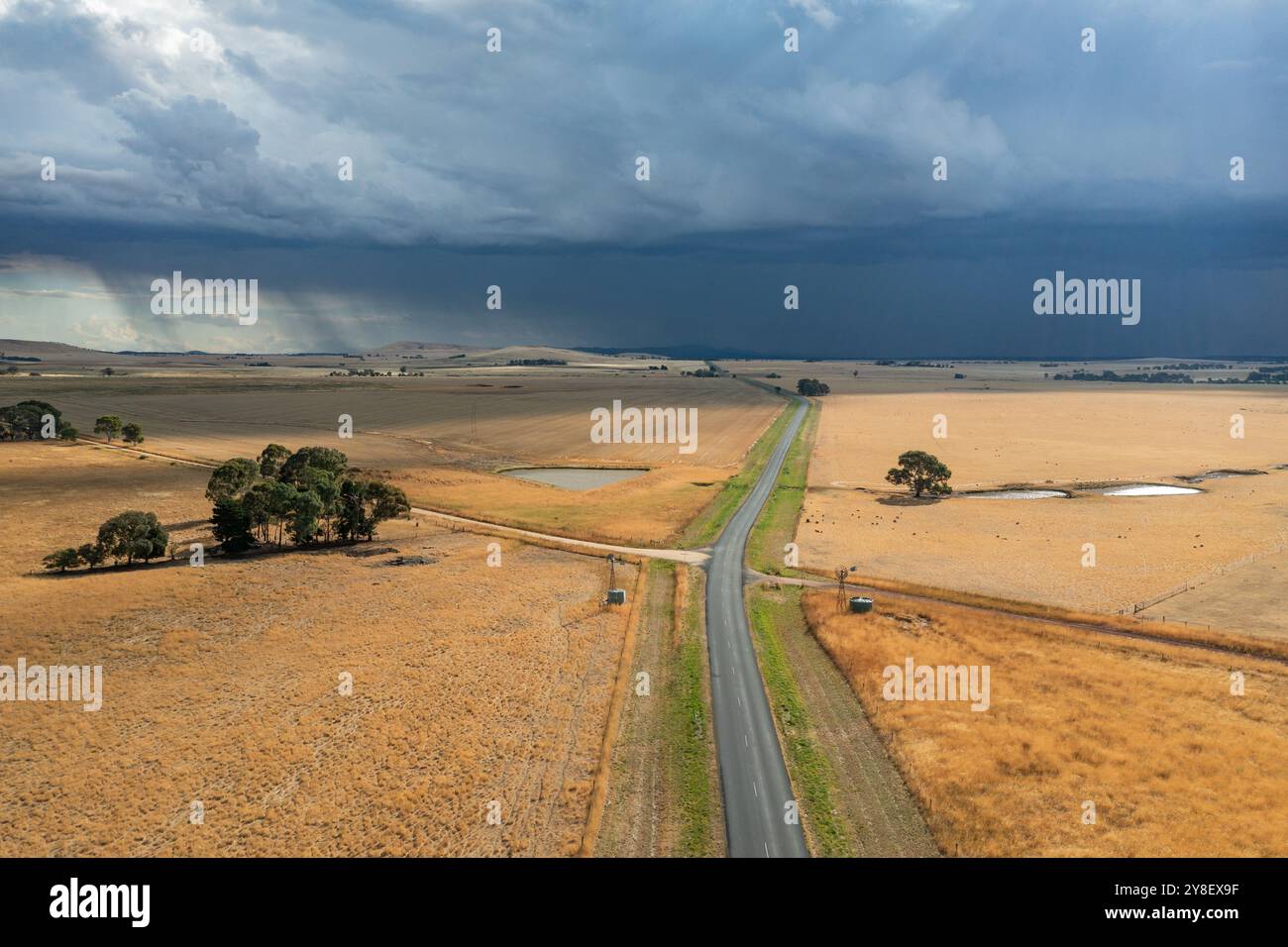 Aerial view of rain falling from a dark storm front over farmland at ...