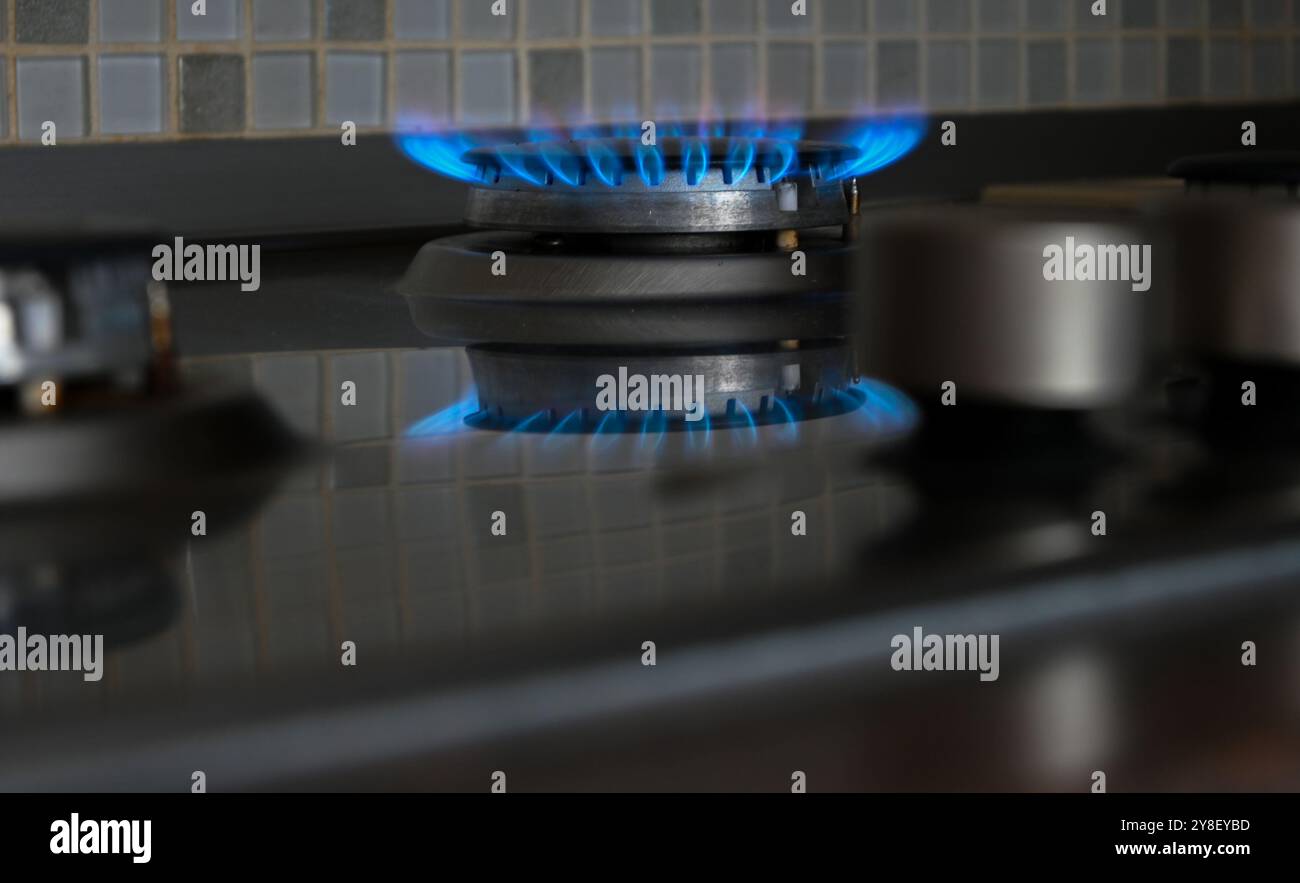 Blue flames burning on a gas stovetop in a modern kitchen Stock Photo ...