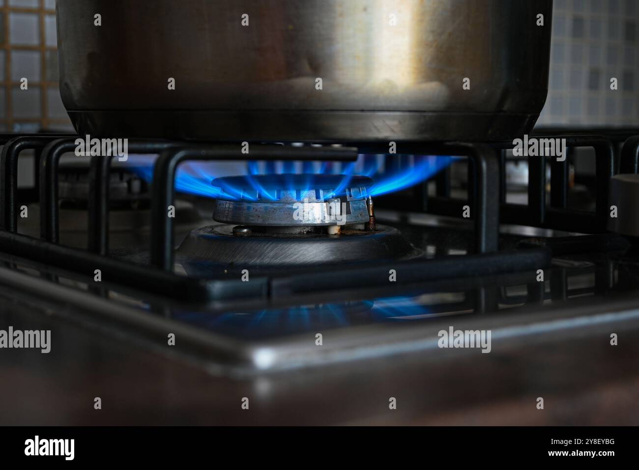 Stainless steel pot is heating on a gas stove with visible blue flames Stock Photo - Alamy