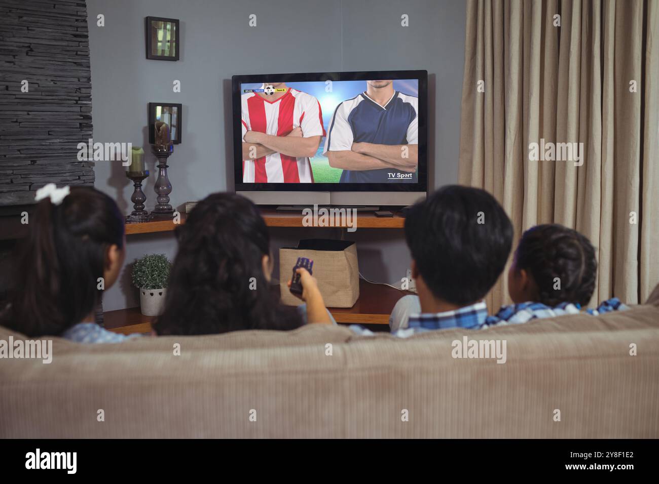 Happy latin family watching football match together and sitting on the ...