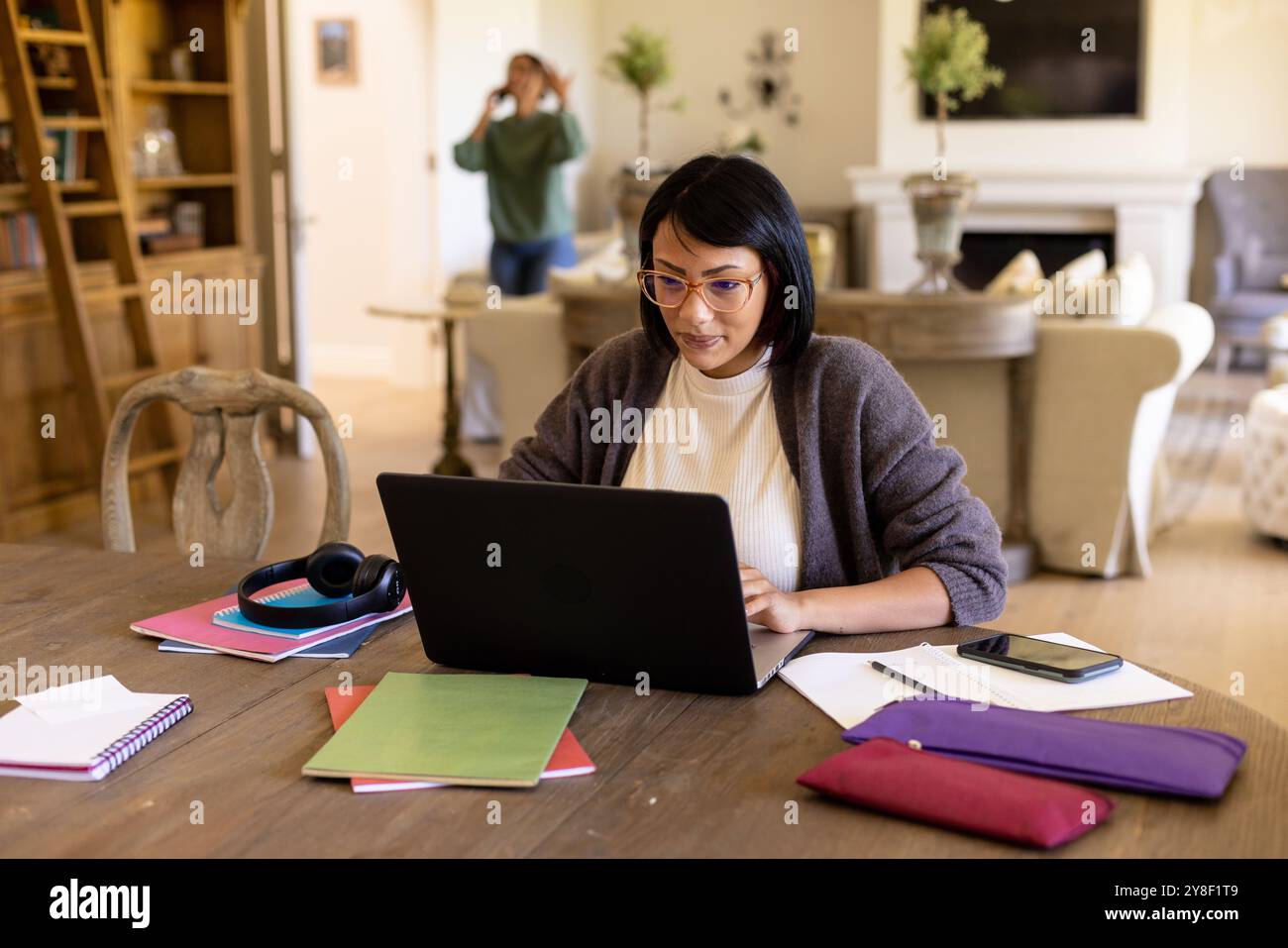 Biracial woman sitting table hi-res stock photography and images - Alamy