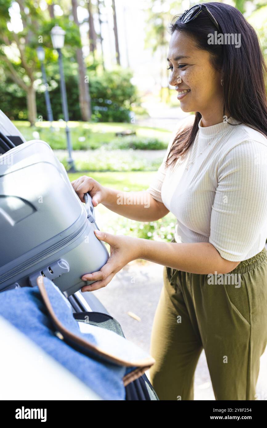 Happy asian woman packing luggage in car in garden at home Stock Photo ...
