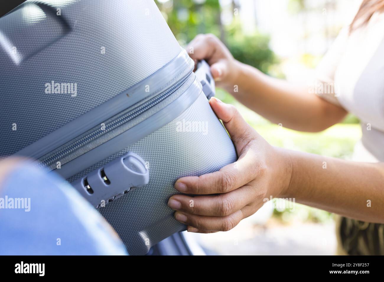 Asian woman packing luggage in car in garden at home Stock Photo - Alamy