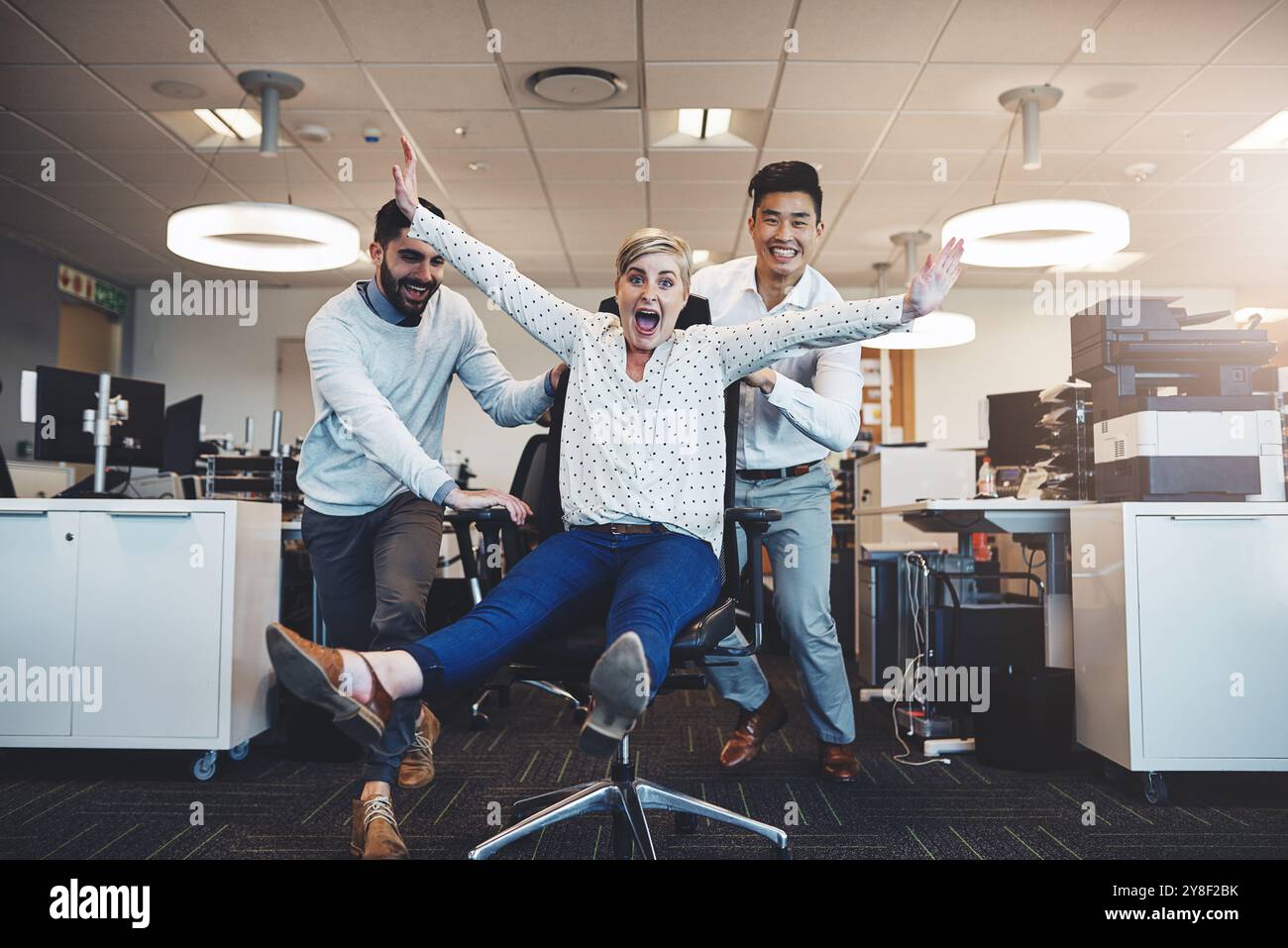 Portrait, chair and colleagues in office, ride and celebration for work ...