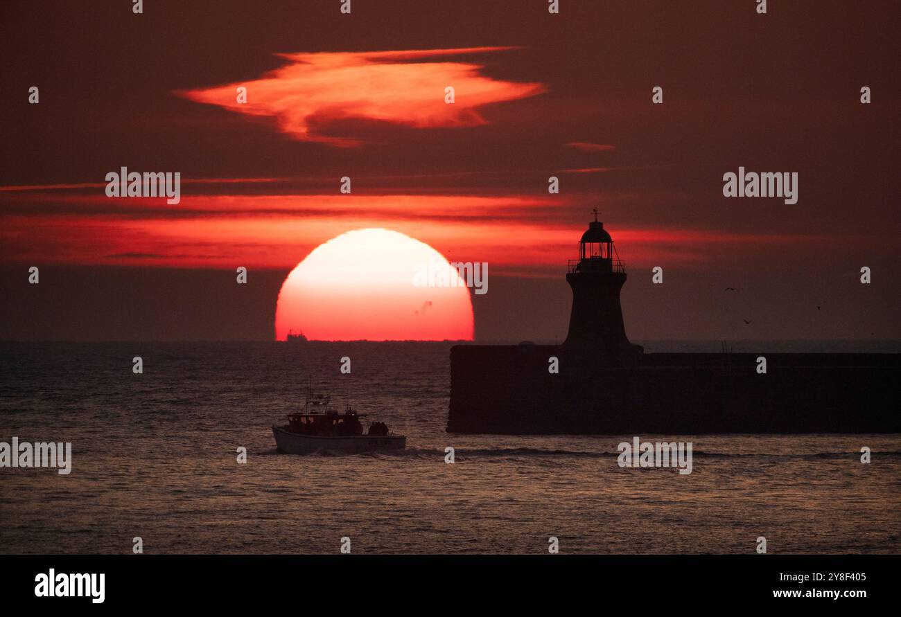 The sun begins to rise behind South Shields lighthouse, on the North ...
