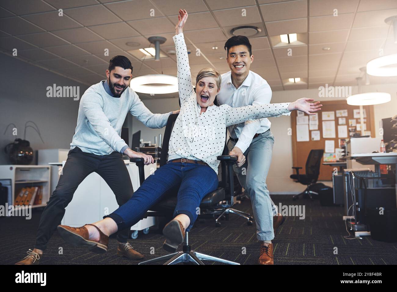 Crazy, chair and colleagues in office, ride and celebration for work ...