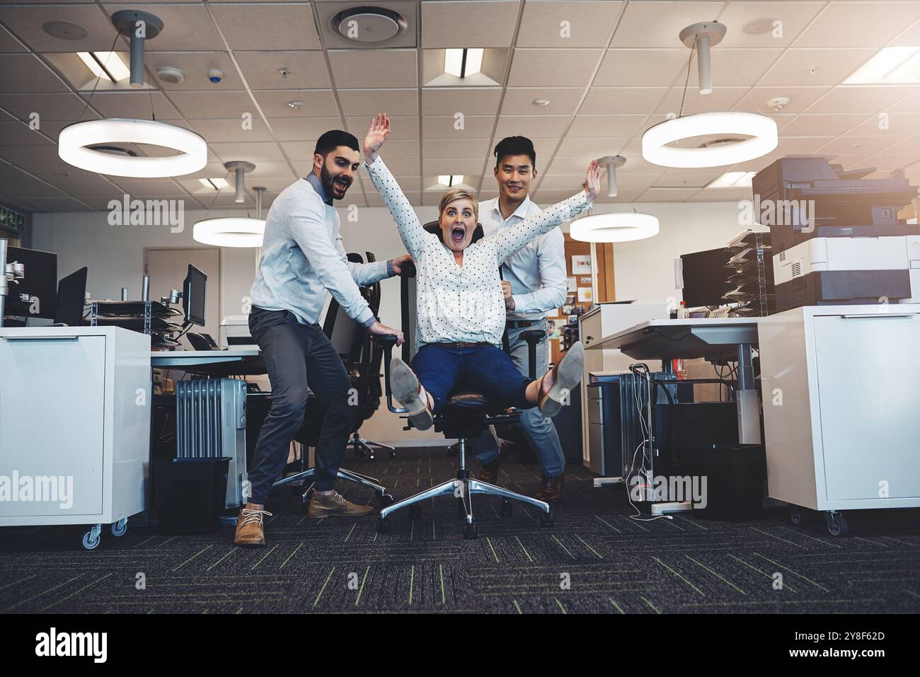 Fun, chair and colleagues in office, ride and celebration for work ...