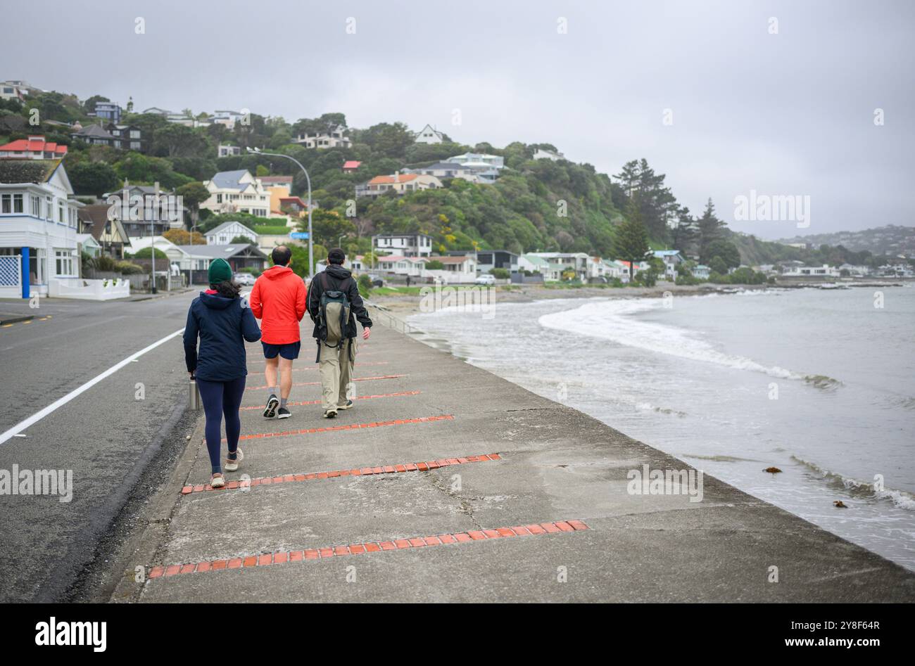 People walking on Plimmerton beach on a cold windy day. Wellington ...