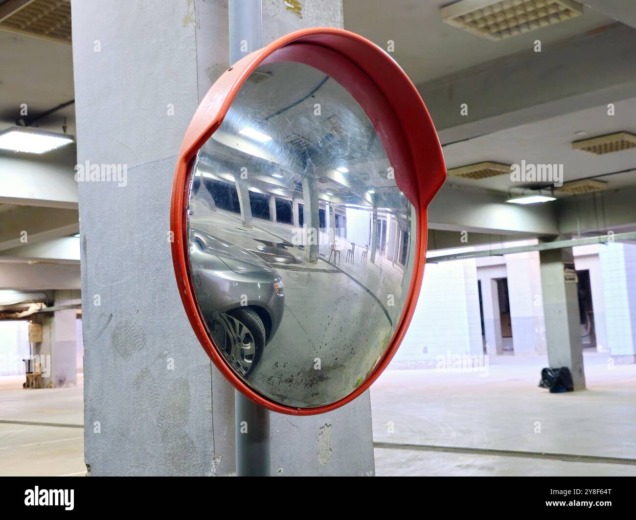 Cairo, Egypt, September 28 2024: A garage parking safety mirror with a KIA Cerato vehicle ...