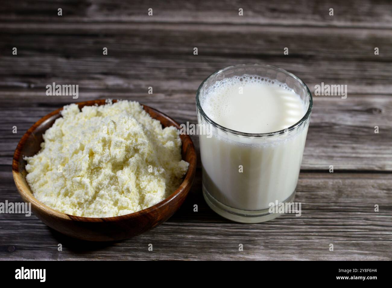 powdered dry milk and glass of milk, a manufactured dairy product made ...