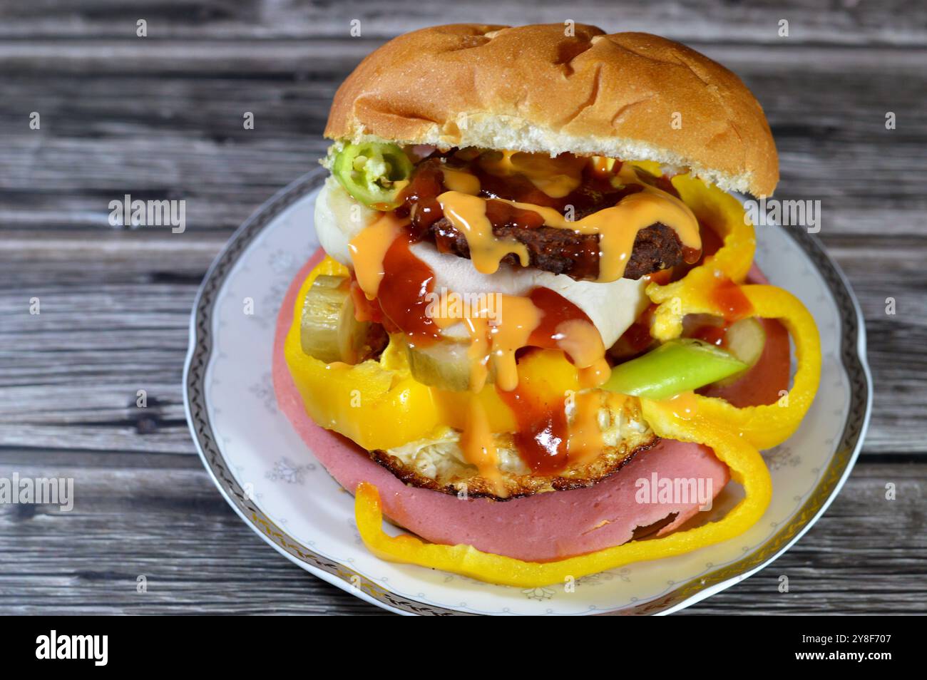 Fried beef burger with slices of pickled cucumbers, onions, luncheon ...